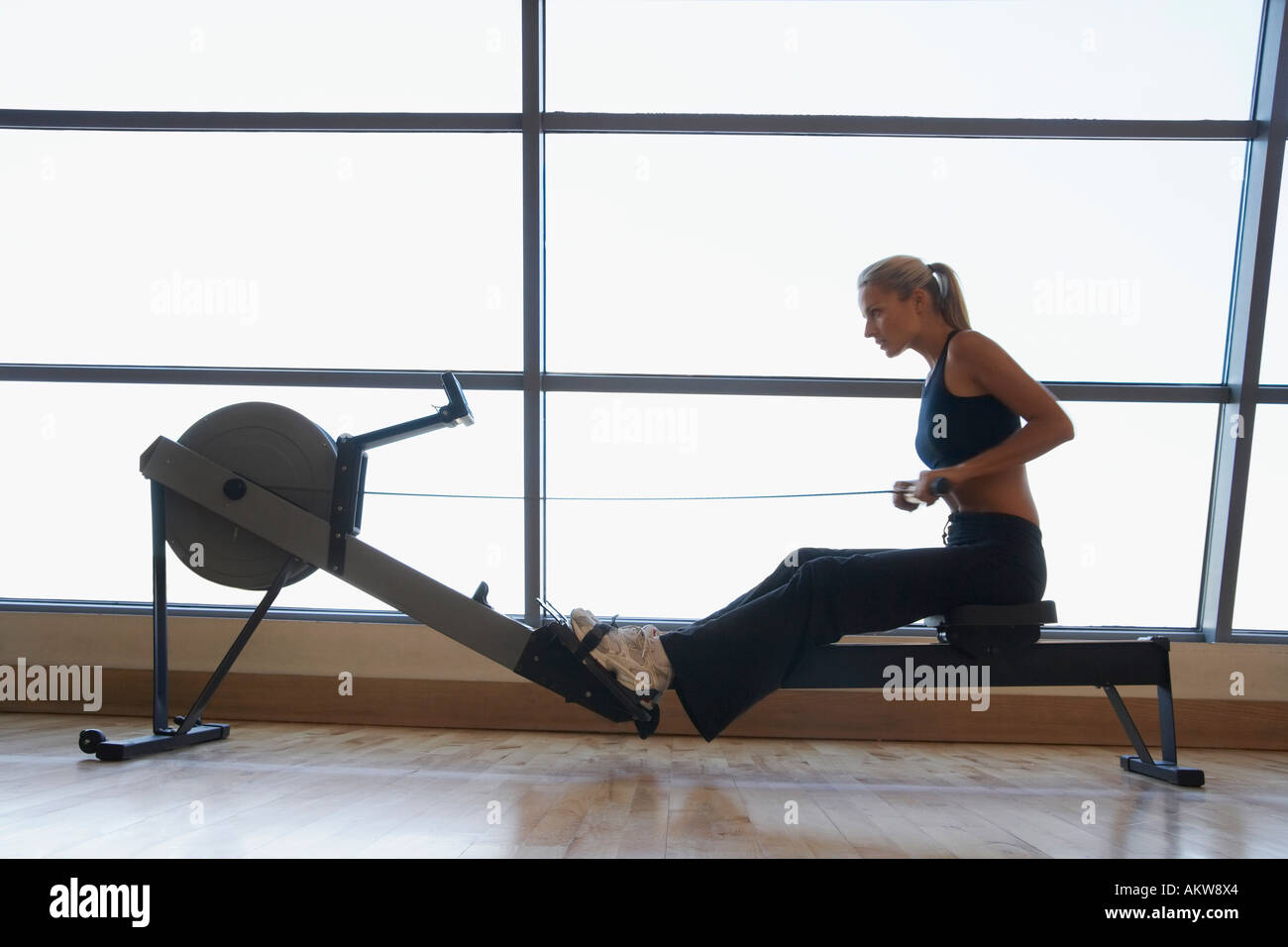 Women Using Rowing Machine in health club, side view Stock Photo - Alamy