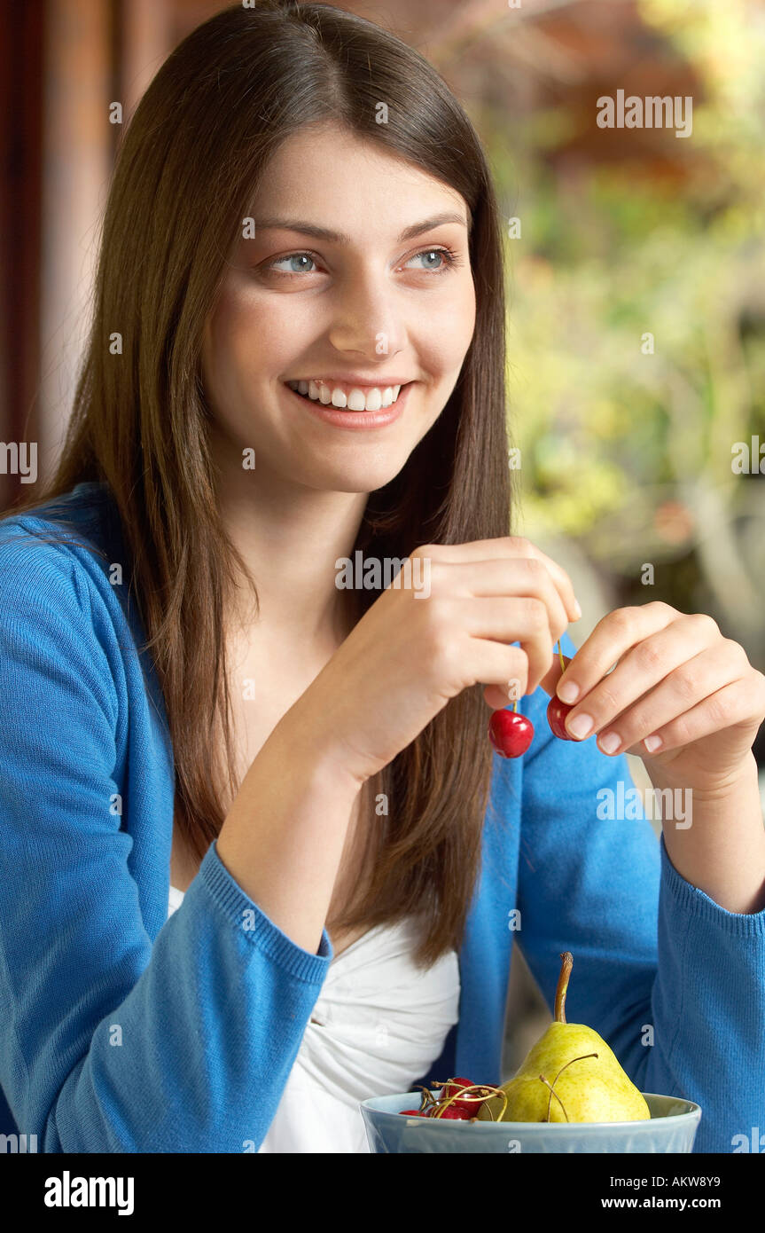 Young woman eating fruit, portrait Stock Photo - Alamy