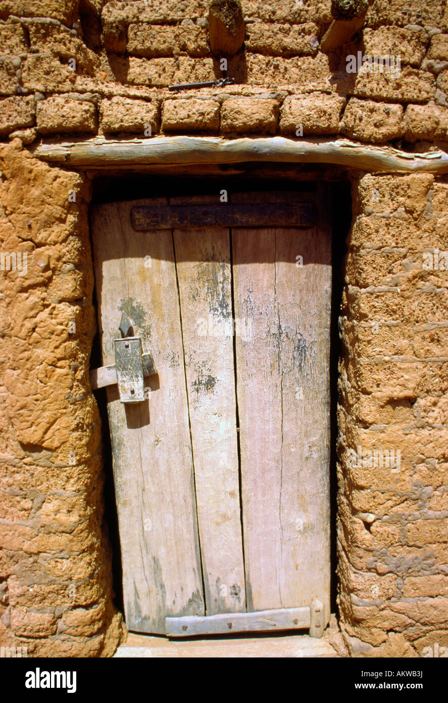 A weathered wooden door on a Dogon village house made of clay Stock ...