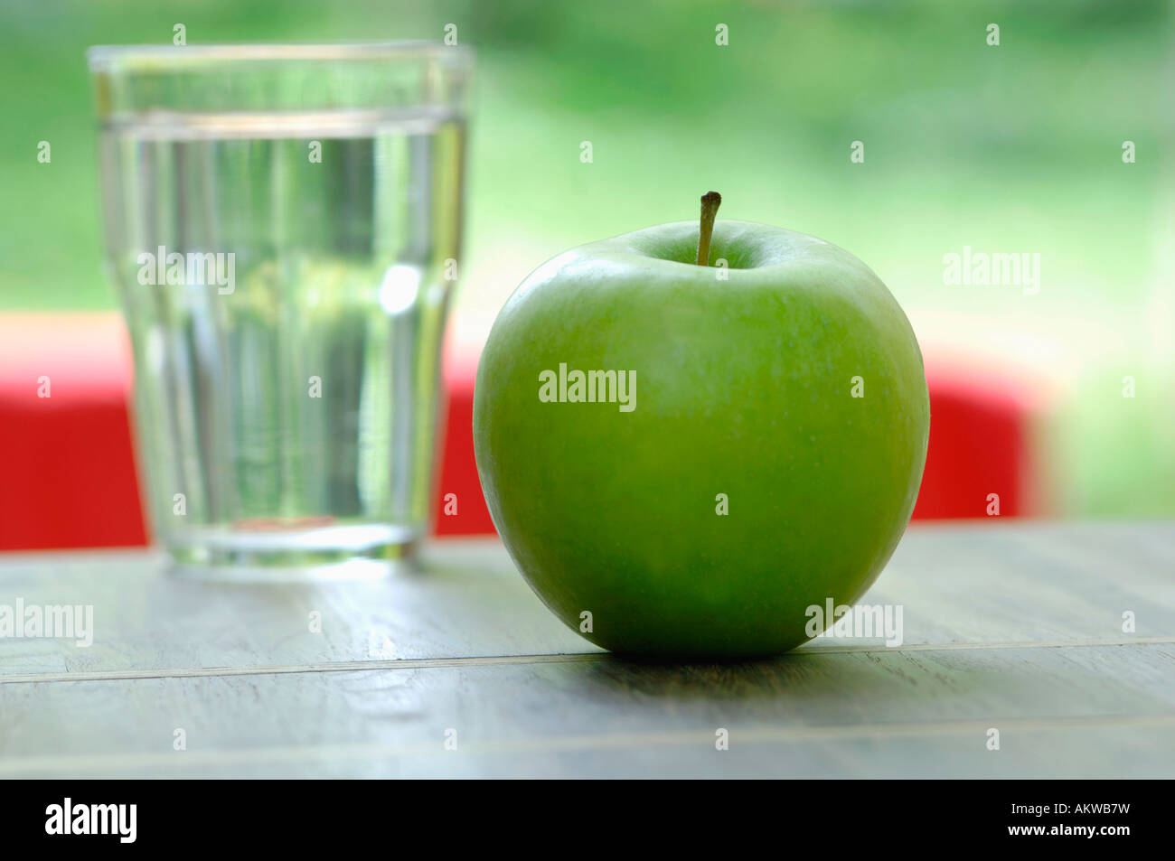 Green apple, beside a glass of water, close-up Stock Photo - Alamy