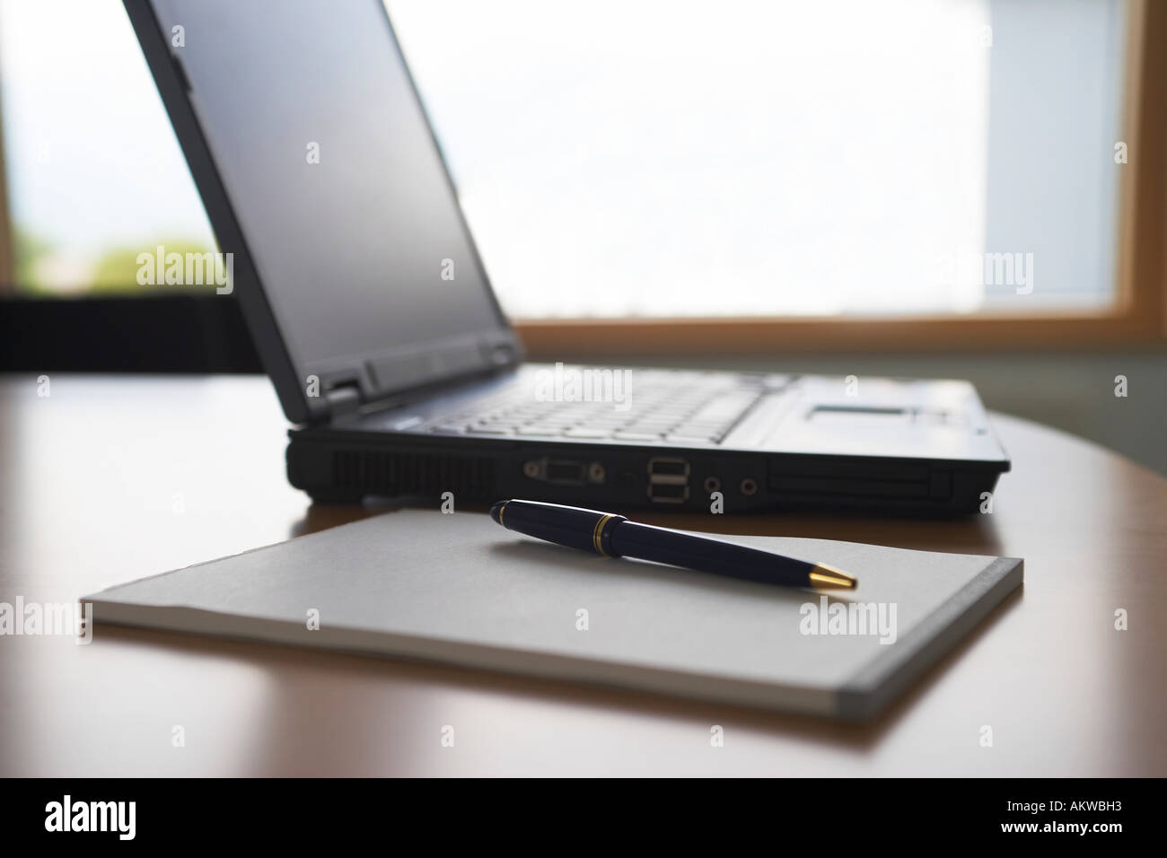 Laptop and notepad on desk Stock Photo - Alamy