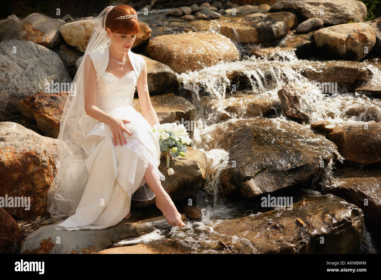 Bride dipping her toe in a stream Stock Photo - Alamy