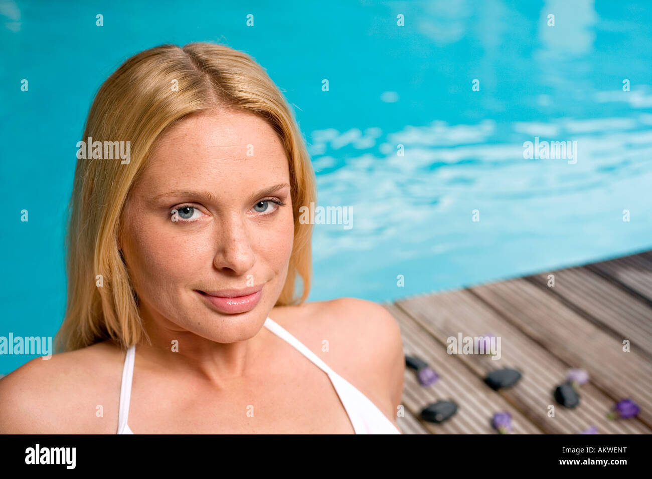 Germany, young woman sunbathing by pool Stock Photo - Alamy