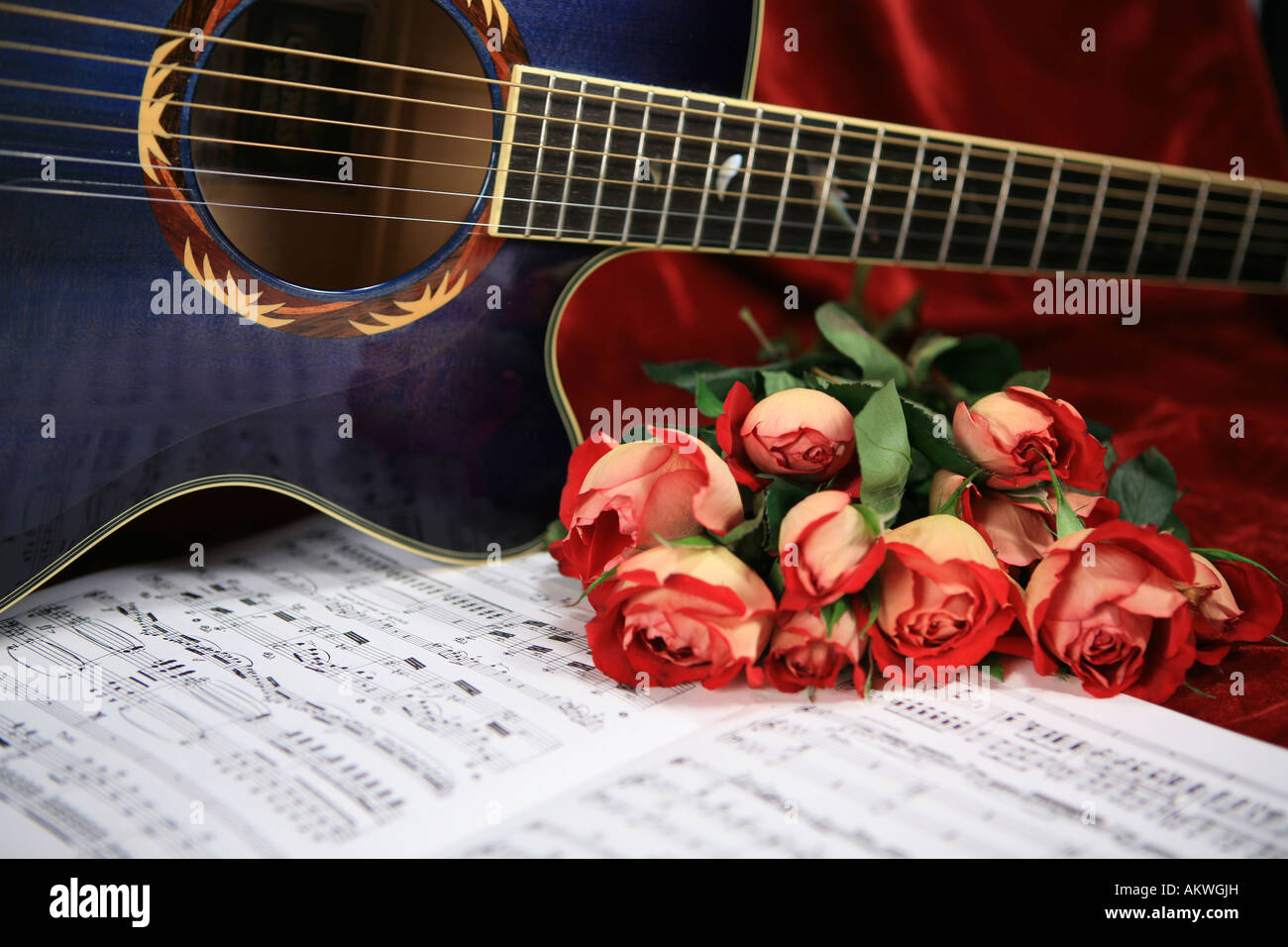 Blue acoustic guitar with roses and sheet music Stock Photo - Alamy