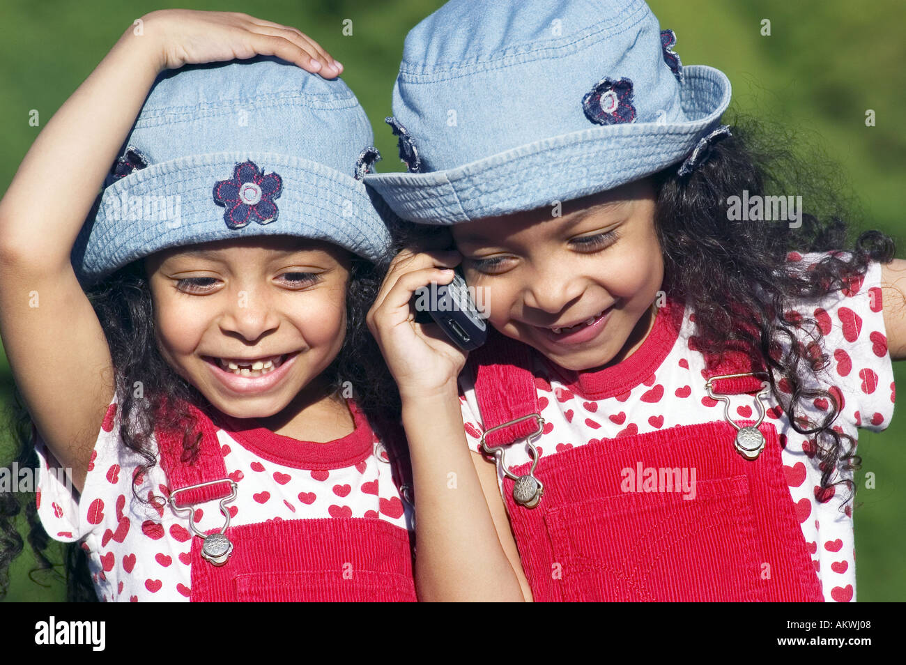 twin sisters talking on mobile phone Stock Photo - Alamy
