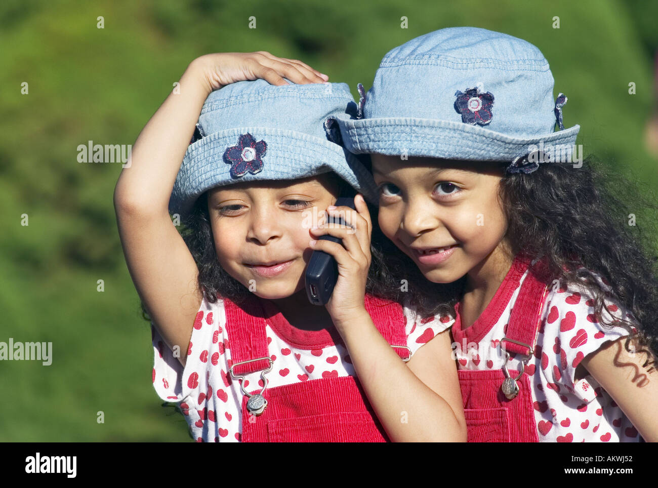 twin sisters talking on mobile phone Stock Photo - Alamy