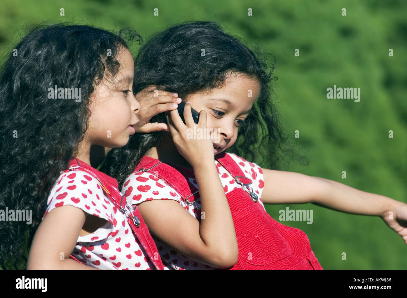 twin sisters talking on mobile phone Stock Photo - Alamy