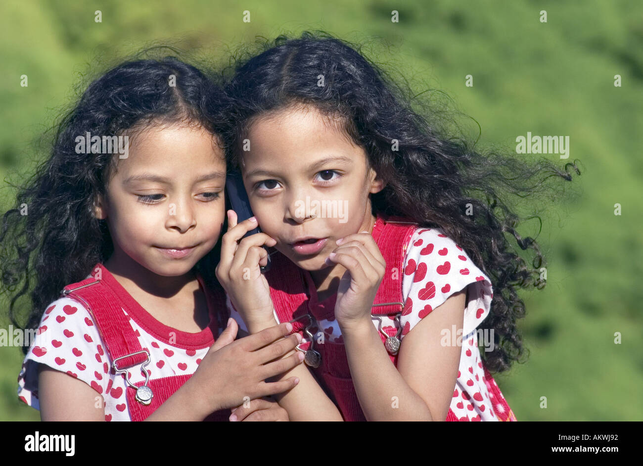 twin sisters talking on mobile phone Stock Photo - Alamy