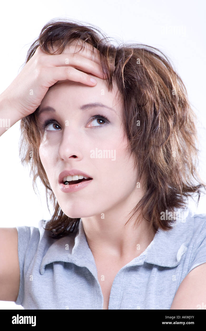 Woman looking up, hand on head, portrait Stock Photo - Alamy