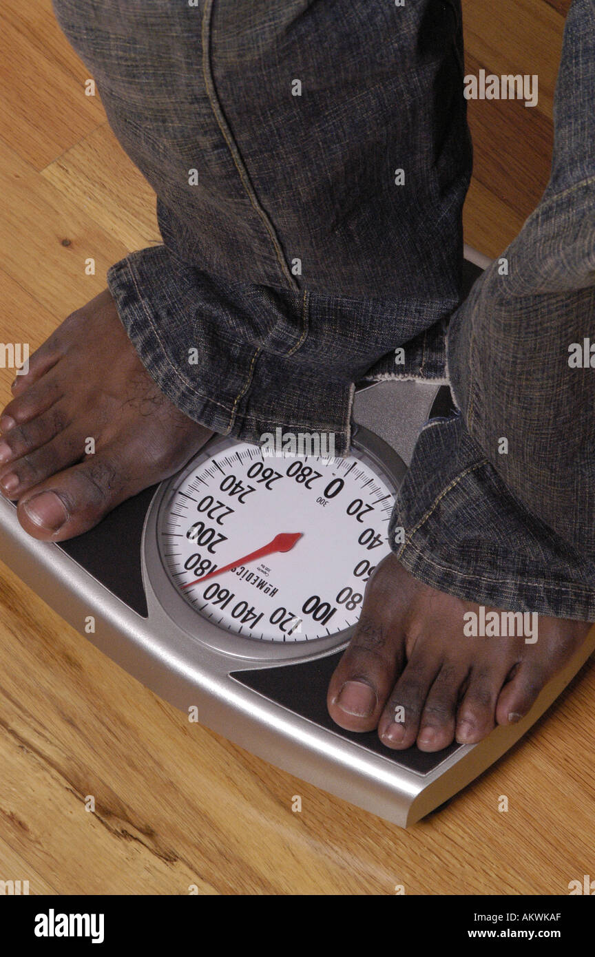 A man's feet on a scale, weighting himself Stock Photo - Alamy