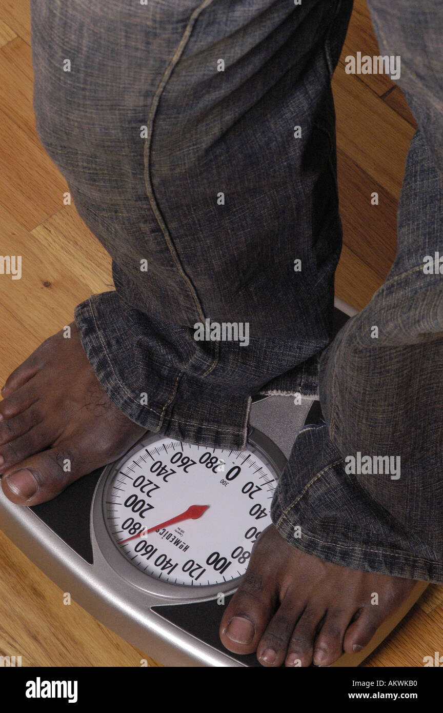 A man's feet on a scale, weighting himself Stock Photo - Alamy