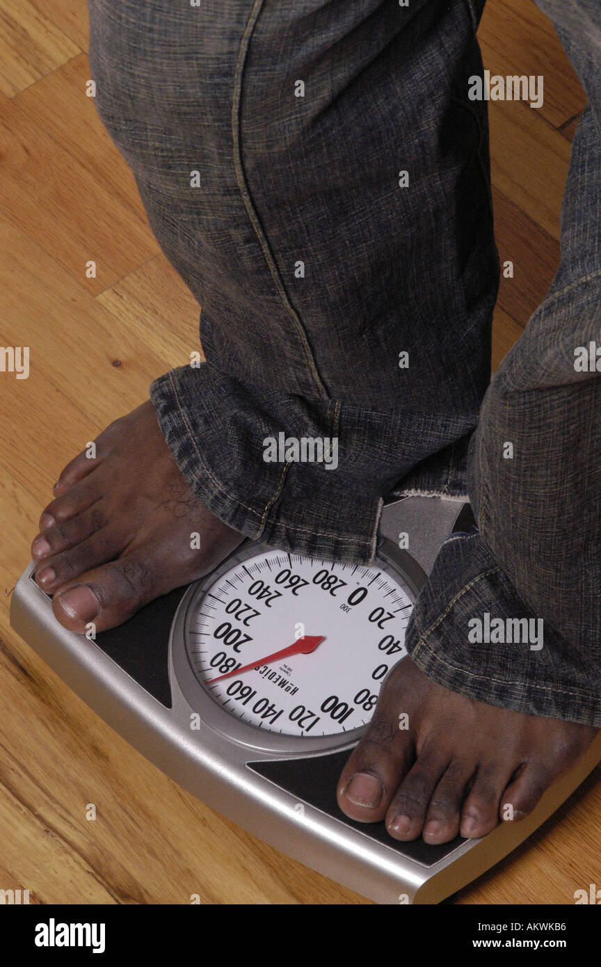 A man's feet on a scale, weighting himself Stock Photo - Alamy