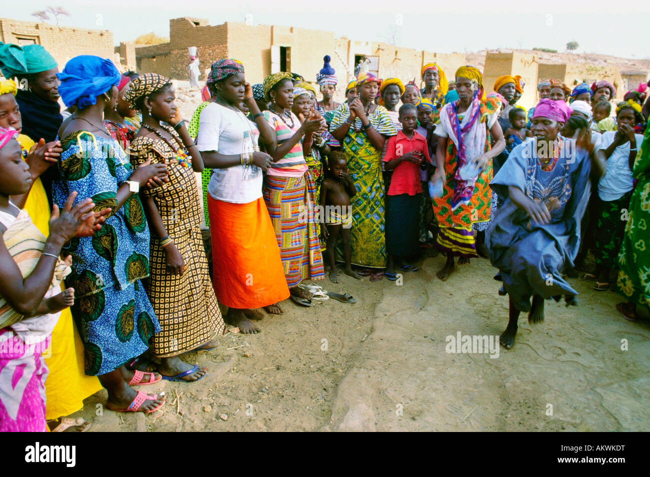 Dogon women gather in a group and take turns dancing during a village ...