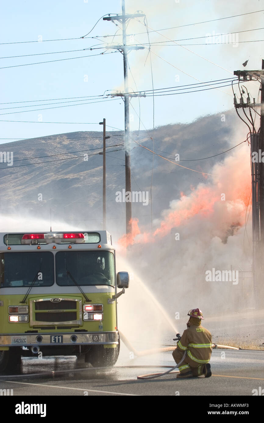 Fireman cooling down a fire truck at an industrial fire Stock Photo - Alamy