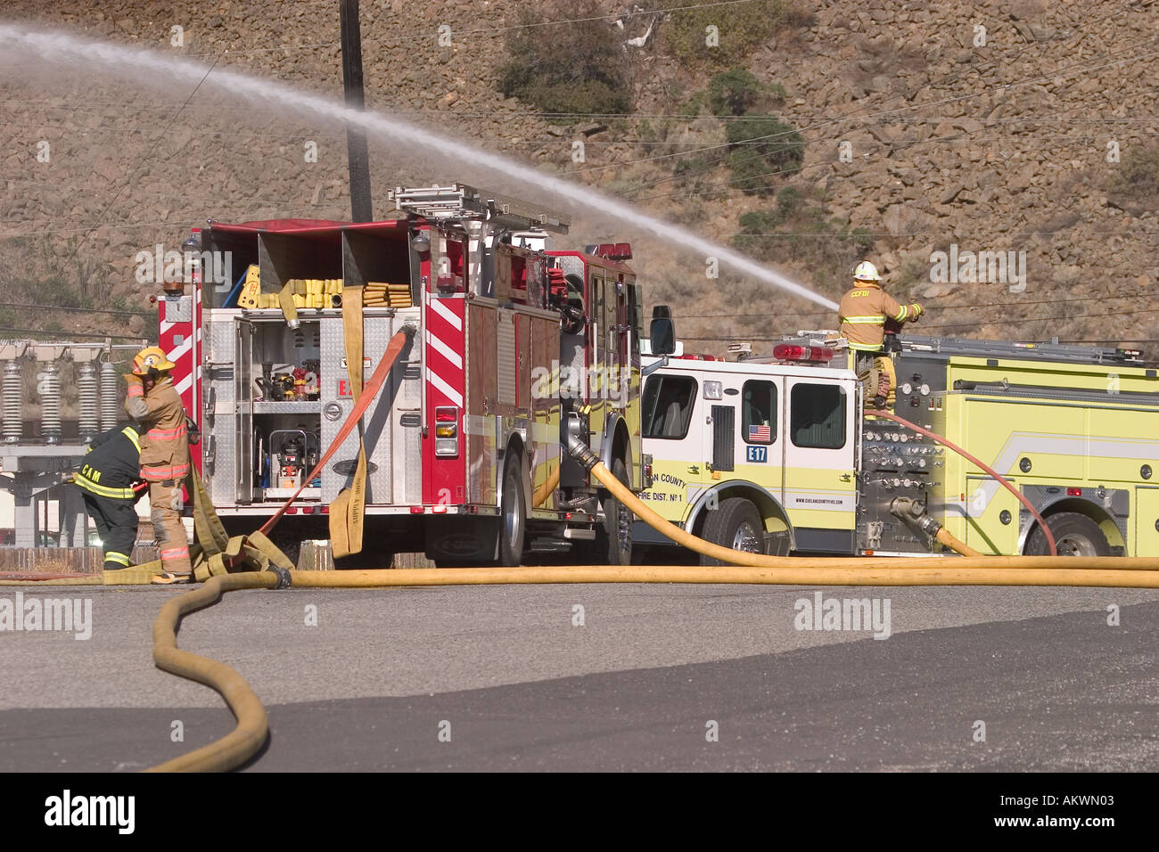 Water being sprayed on a large industrial fire from nozel on fire truck ...