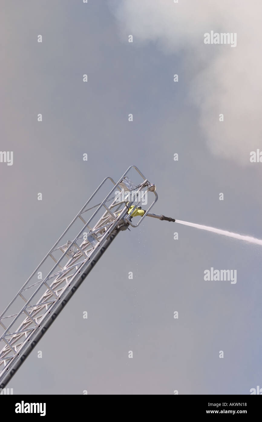 Water being sprayed on a large industrial fire from a boom ladder Stock ...