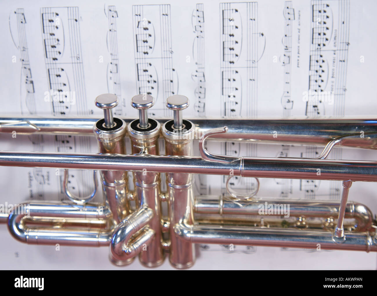 Silver trumpet on top of sheet music Stock Photo - Alamy
