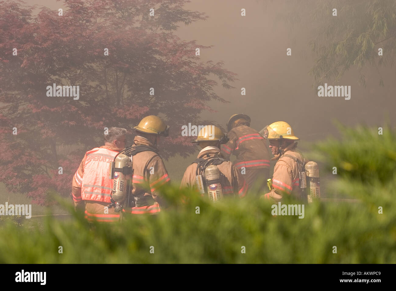 Firemen fighting a house fire with smoky background Stock Photo - Alamy
