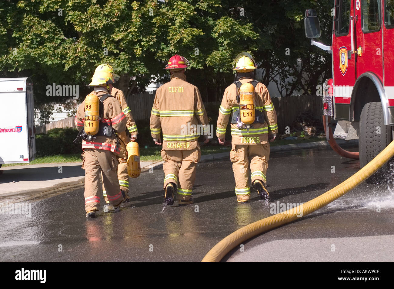 Firemen walking past fire truck towards a house fire Stock Photo - Alamy