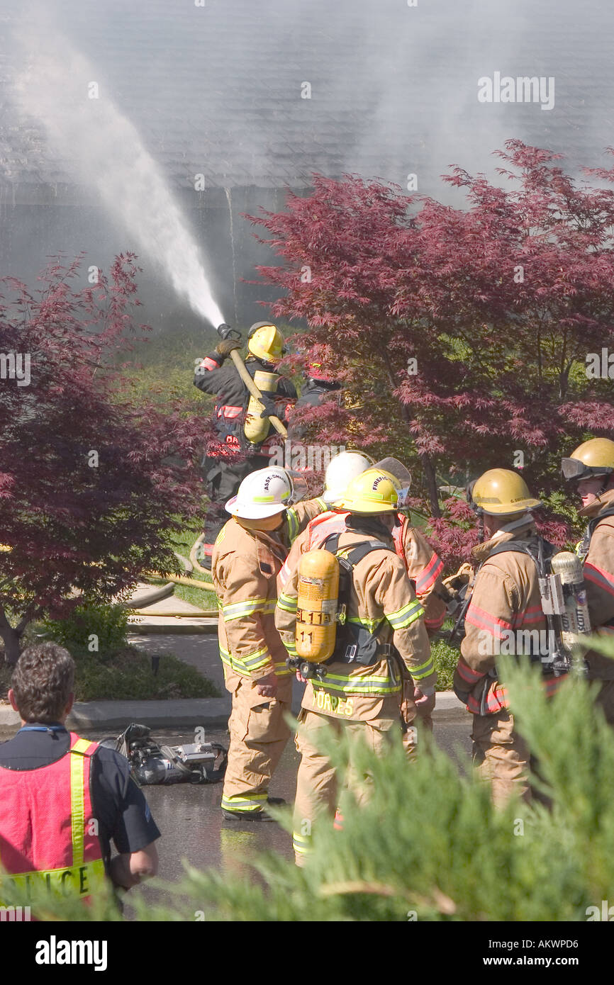 Fireman spraying water on a house fire with smoky background Stock ...