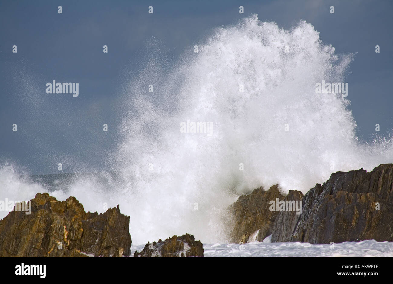 a huge wave hitting rocks on the shore Stock Photo - Alamy