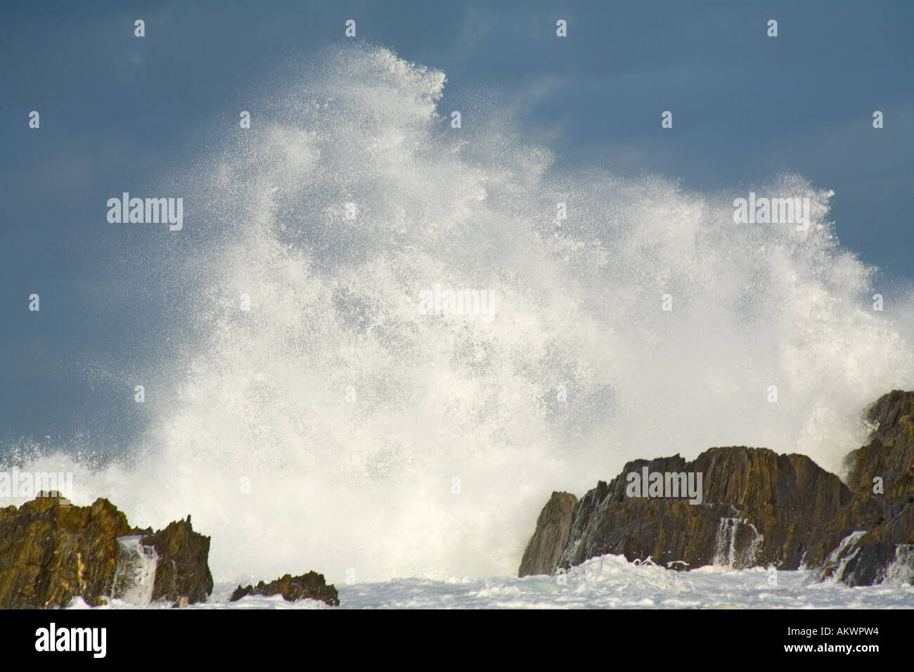 a huge wave hitting rocks on the shore Stock Photo - Alamy