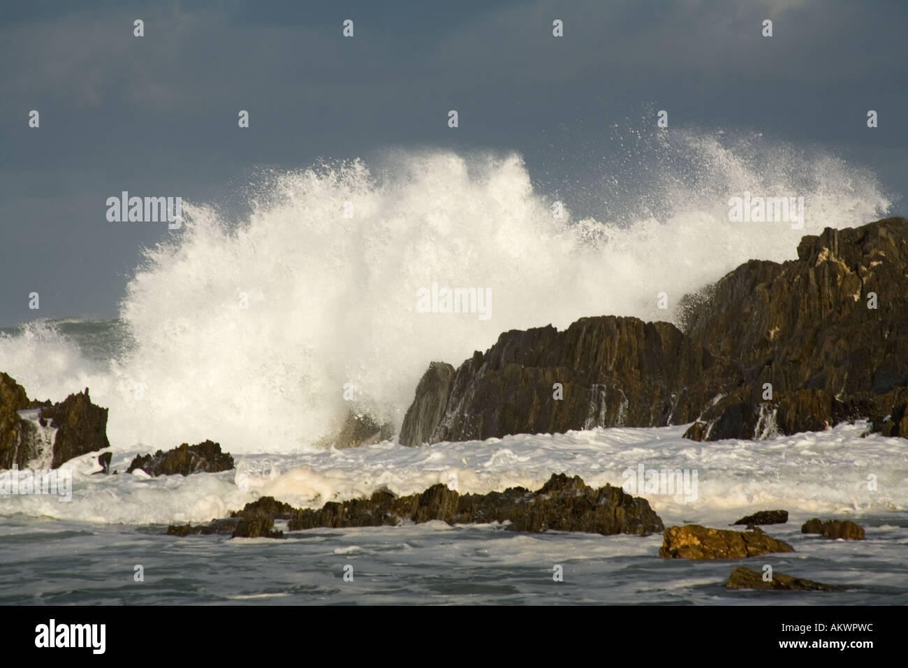 a huge wave hitting rocks on the shore Stock Photo - Alamy
