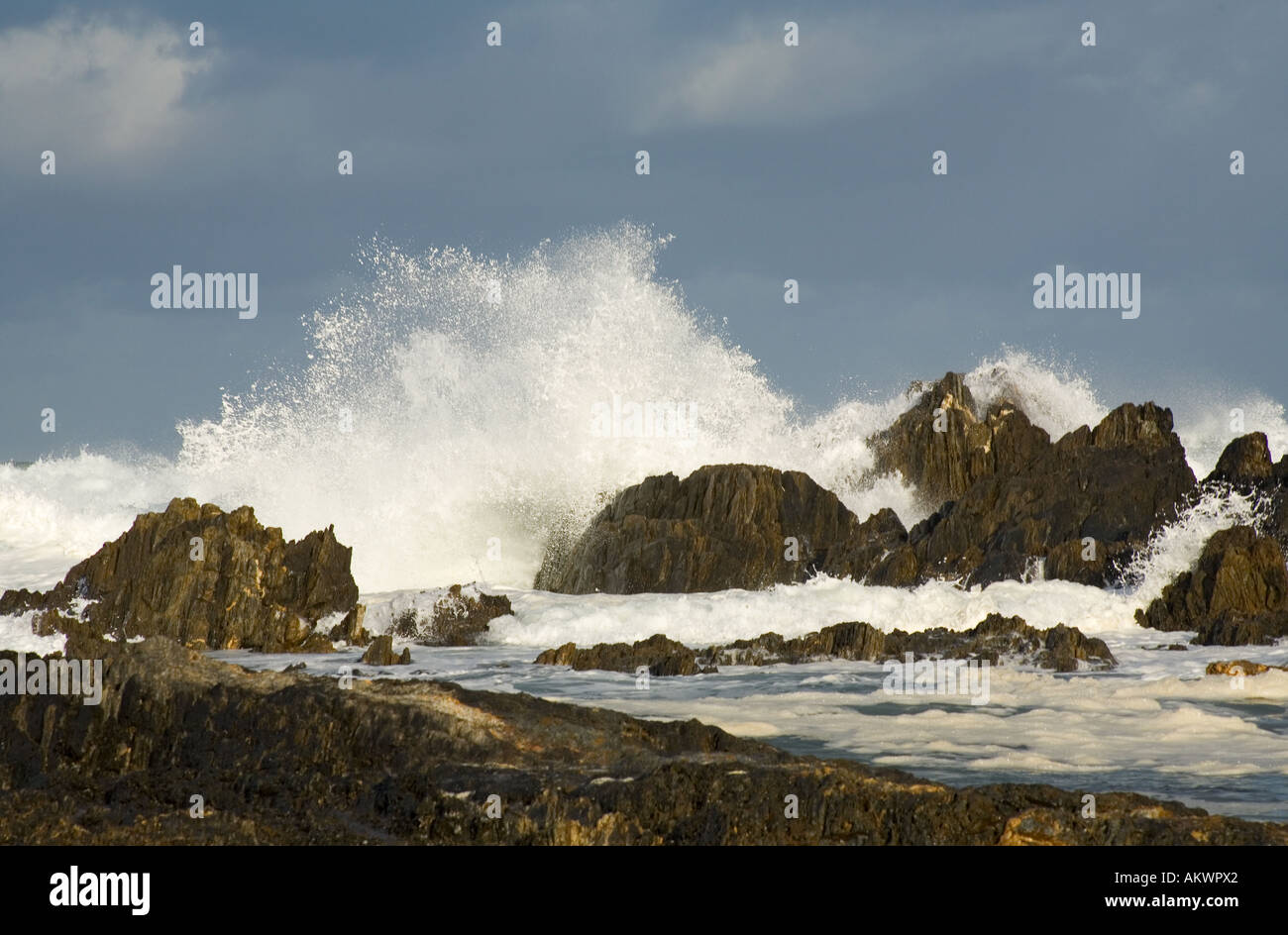 a huge wave hitting rocks on the shore Stock Photo - Alamy