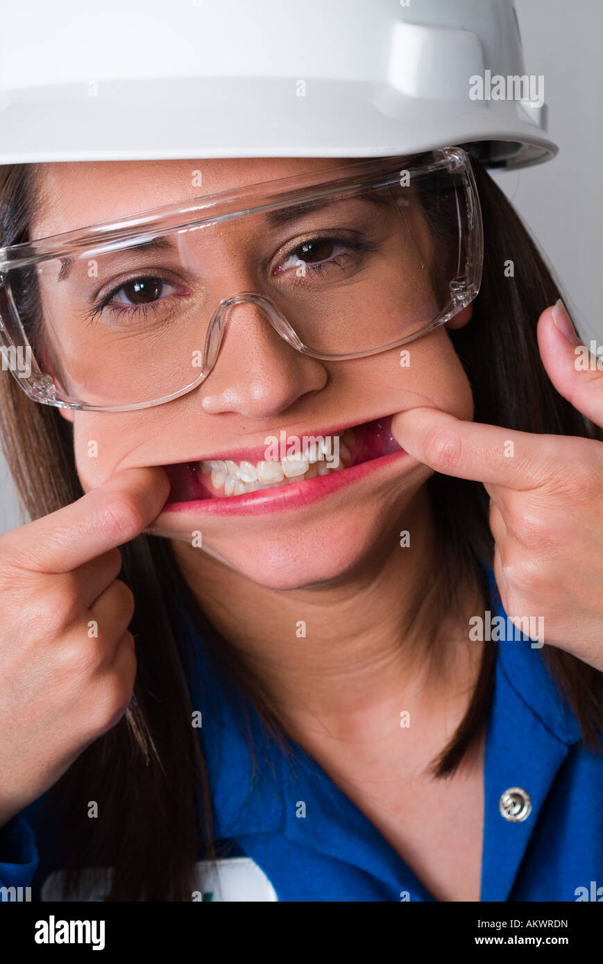 Young female engineer in coveralls making smiley face Stock Photo - Alamy