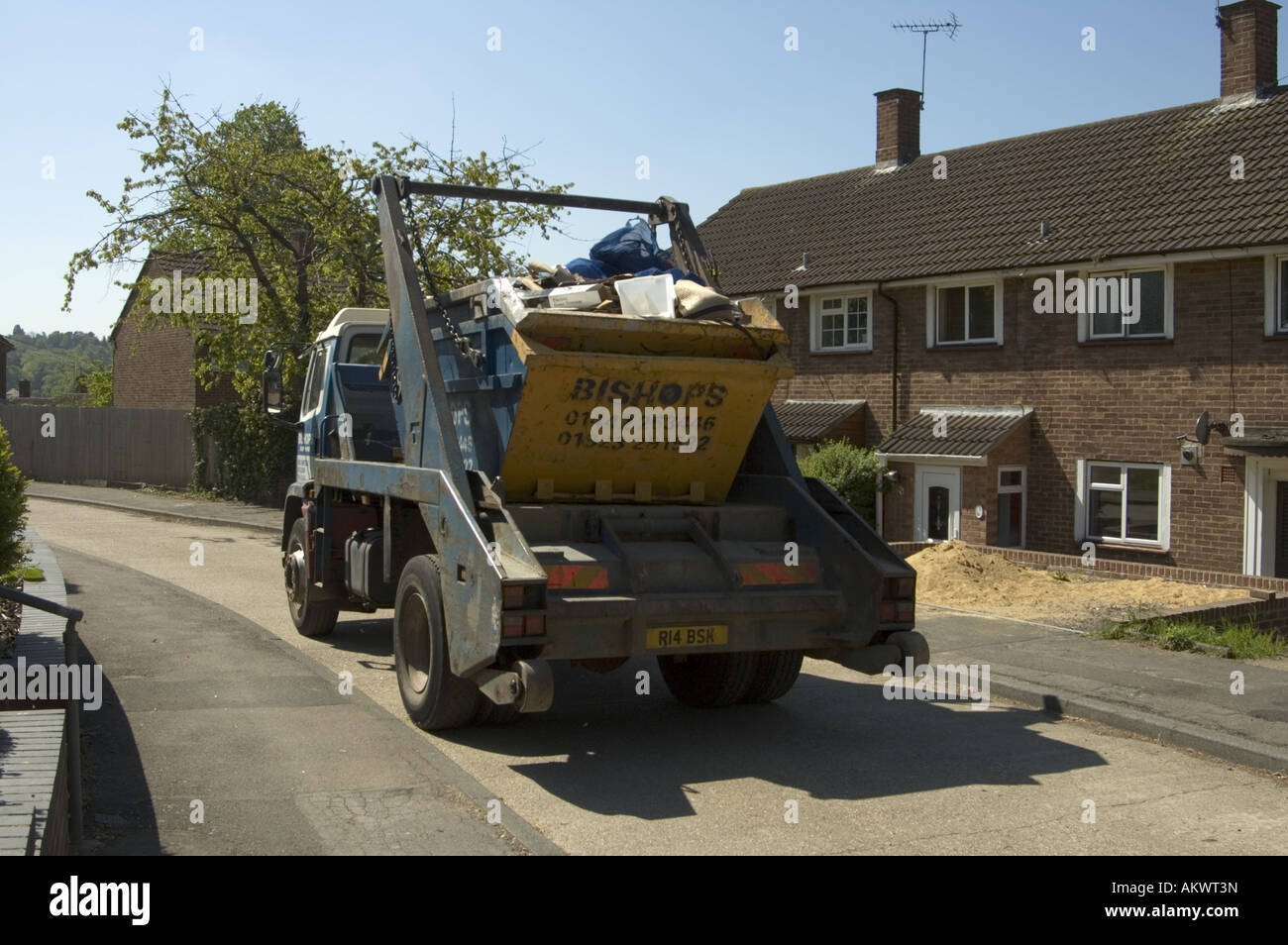 A loaded skip lorry in a narrow suburban street, Hertfordshire, UK ...