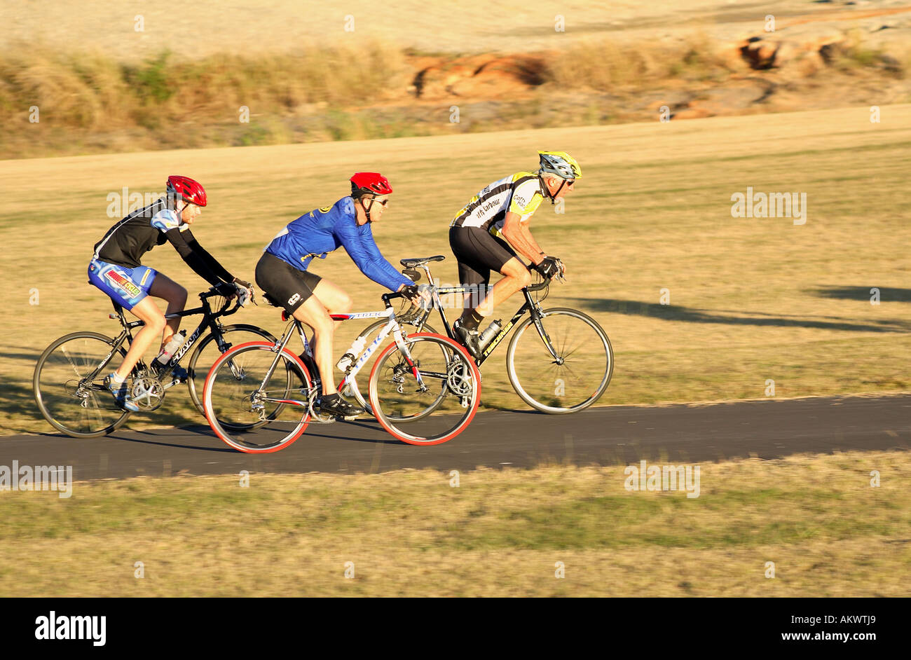 three bicycle riders racing on the track Stock Photo - Alamy
