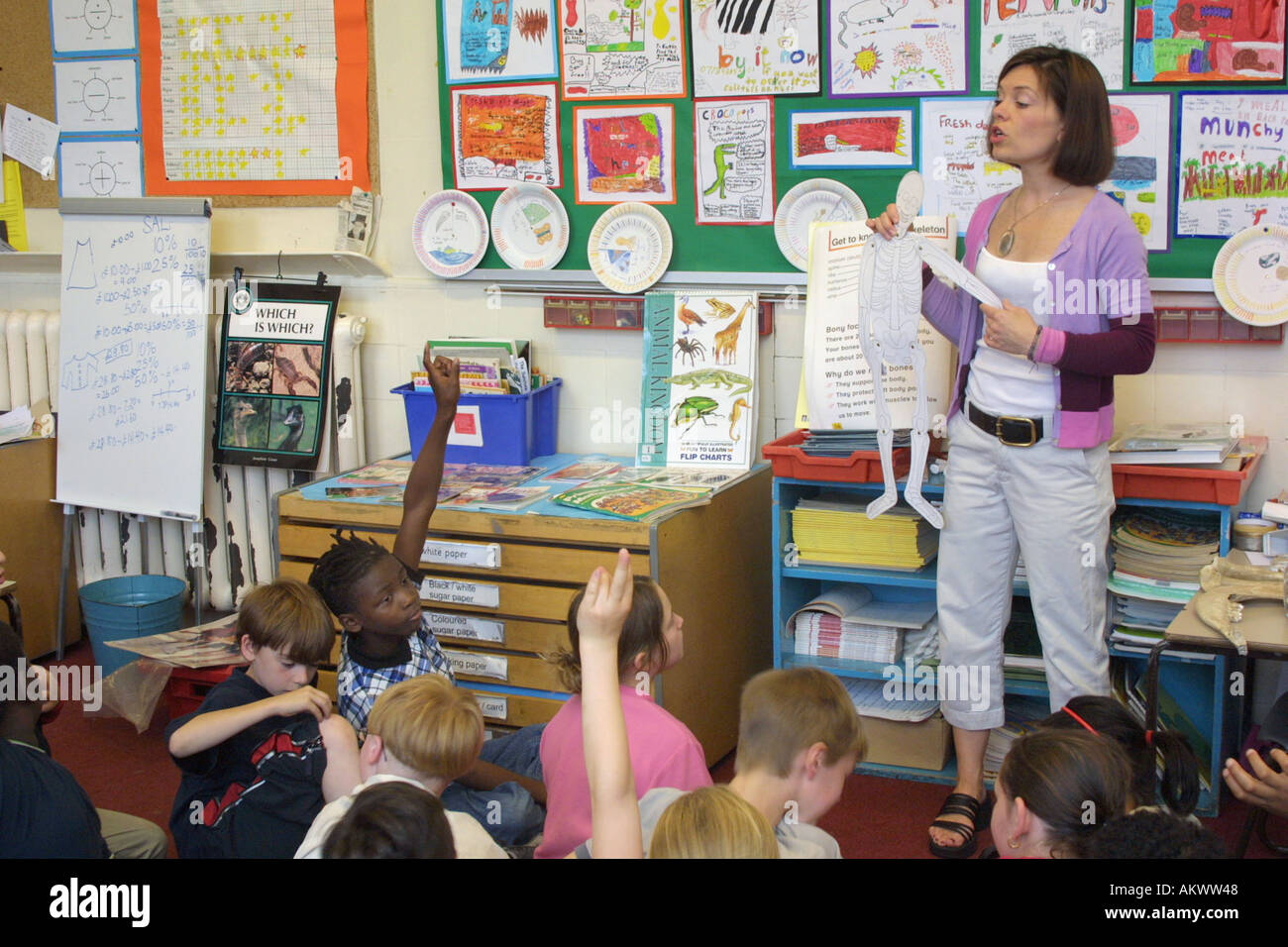 primary children with teacher teaching a lesson Stock Photo - Alamy