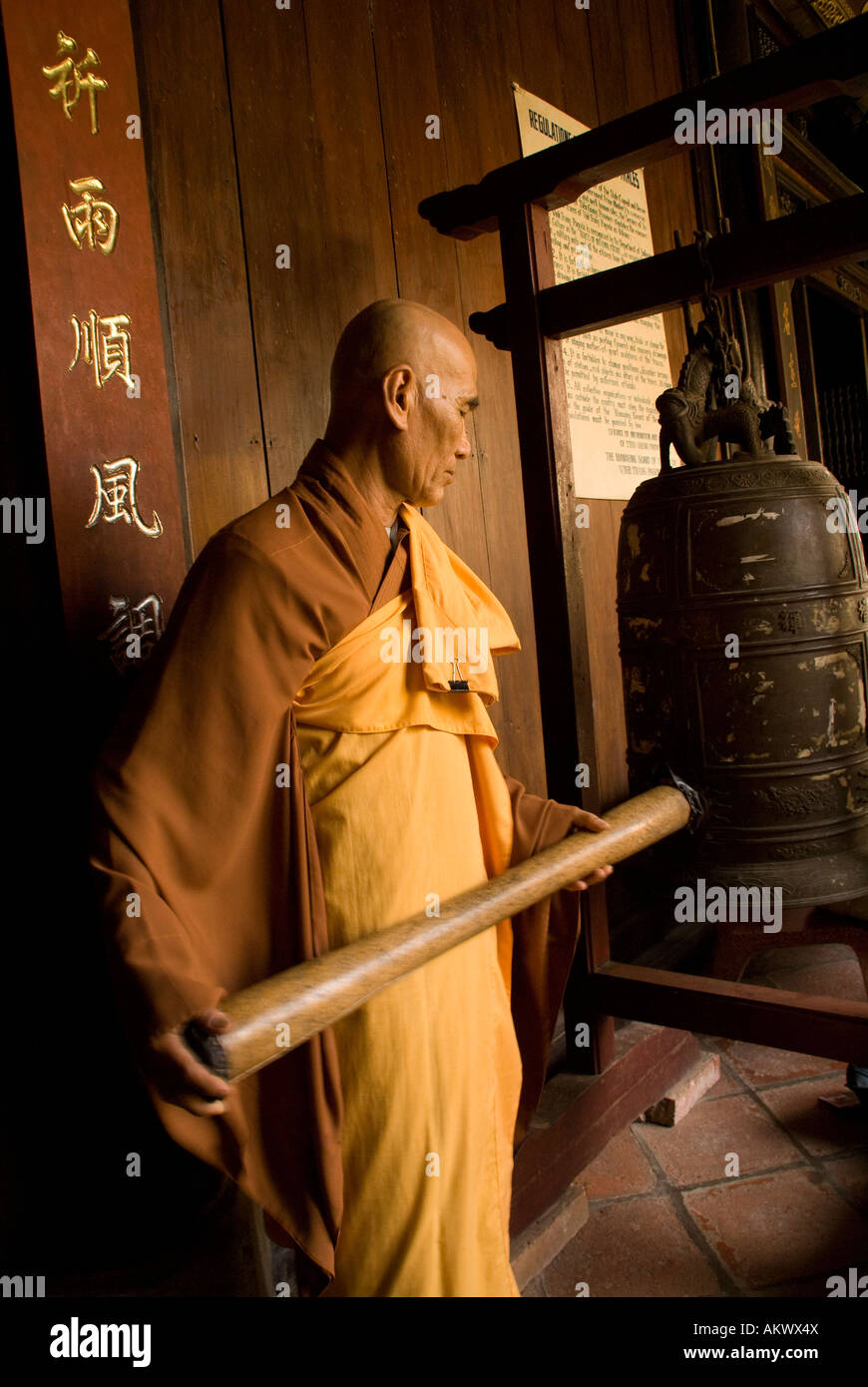 Monk ringing bell at Vinh Trang Pagoda Buddhist temple at My Tho in the ...