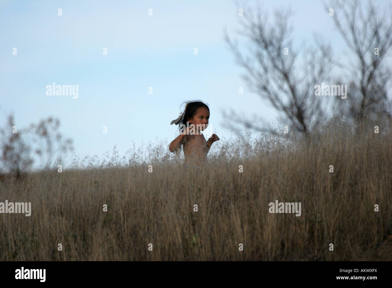 A Native American Indian boy running in the dried grasses Stock Photo ...