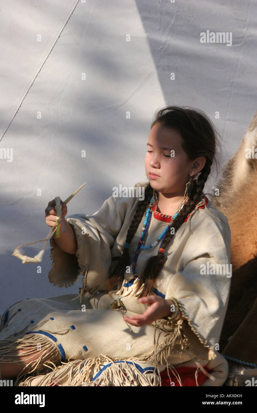 A young Native American Indian child playing with native primitive toys ...