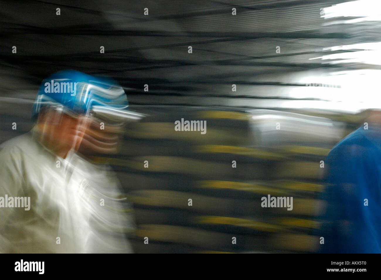 Worker with blue hard hat in motion Stock Photo - Alamy