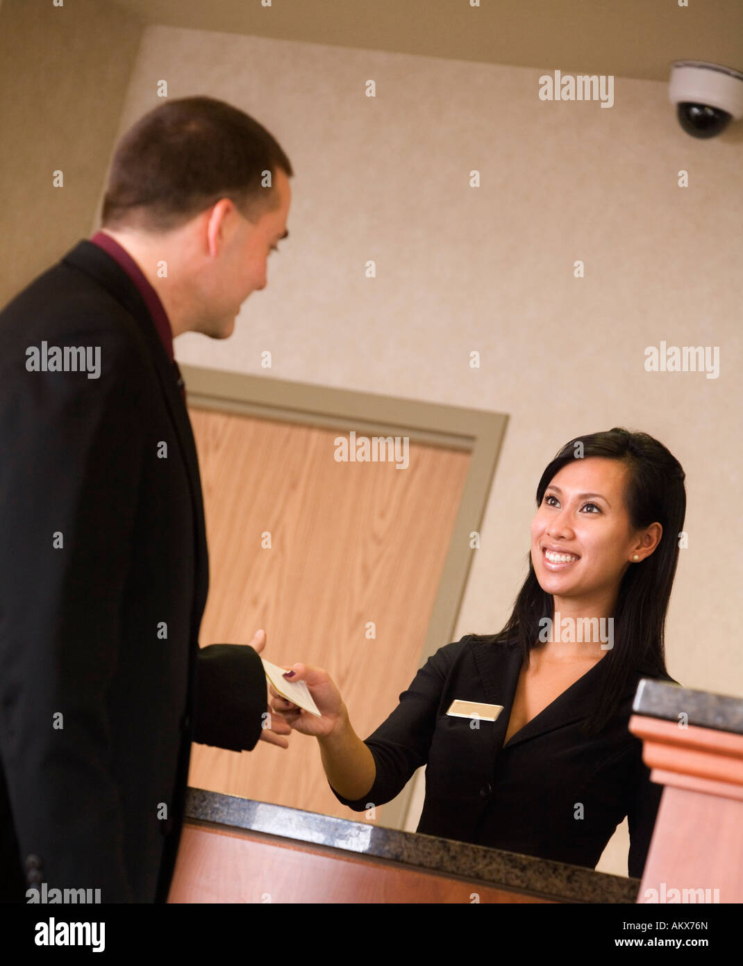 Man and woman at front desk Stock Photo - Alamy