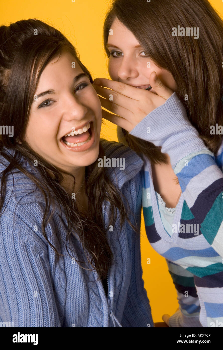 Girl whispering into teenage girls ear hi-res stock photography and ...
