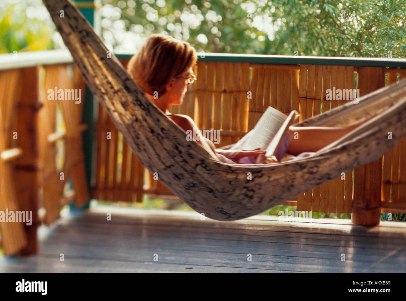 Woman reading in hammock Stock Photo - Alamy