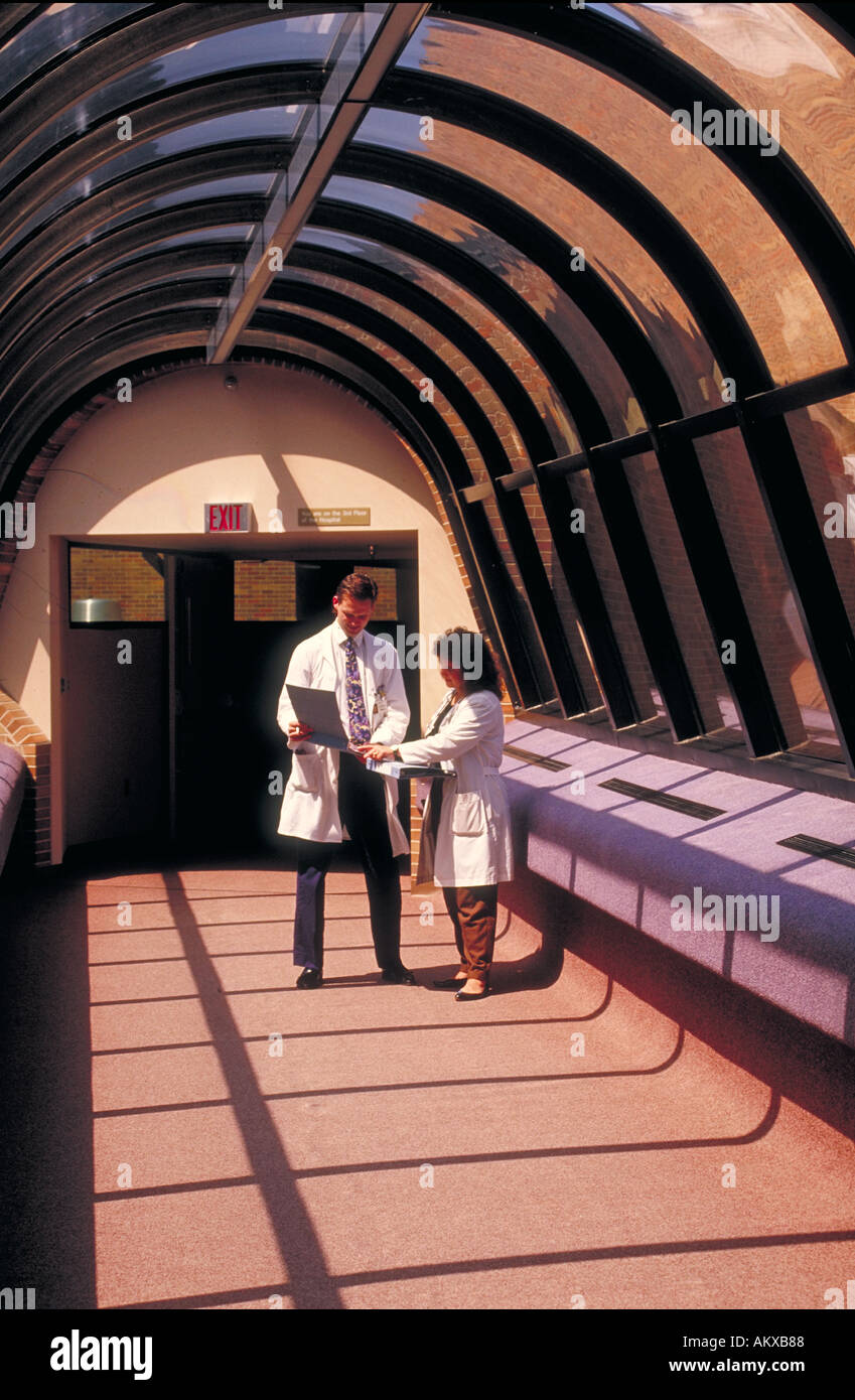 Doctor and nurse consult in hospital hallway Stock Photo - Alamy