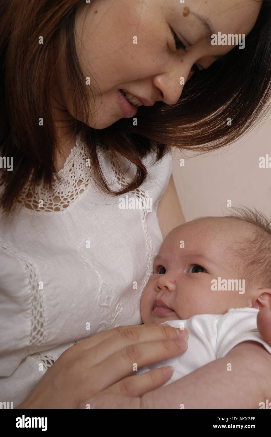 A mother cradling her baby Stock Photo - Alamy