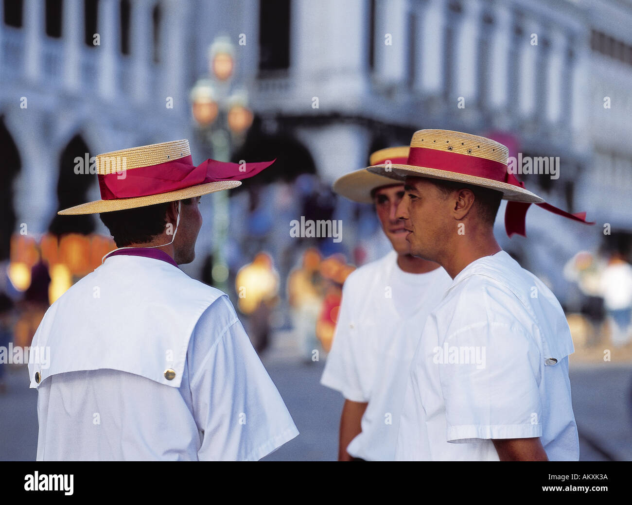 Three young gondoliers in traditional uniform of white shirt and straw ...