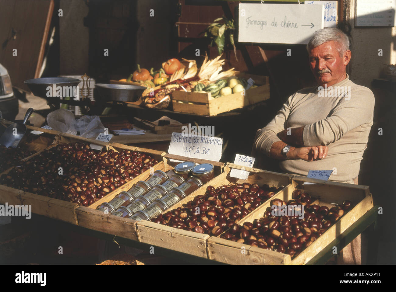 A stallholder seated behind his stall displaying boxes filled with ...