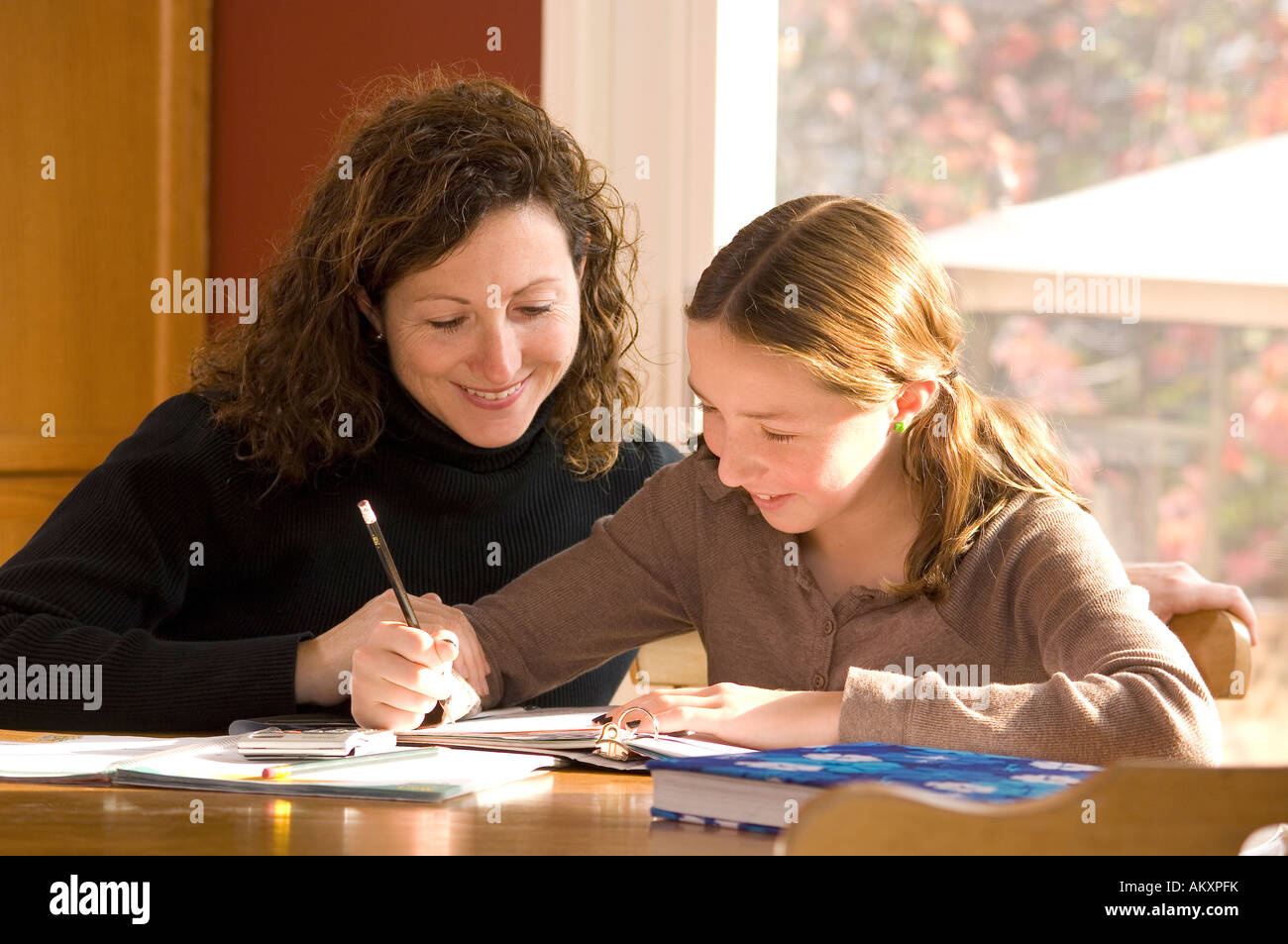 Mother helping her daughter with homework Stock Photo - Alamy