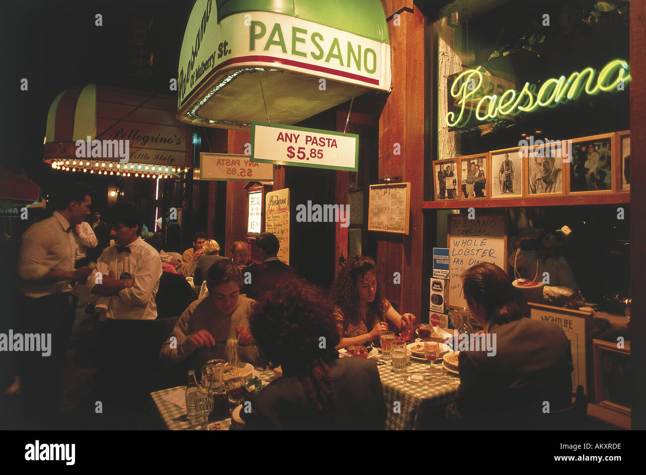 Diners relax at their pavement tables and chat over their meal beneath ...