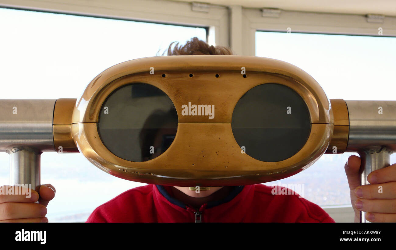 Young boy looking through sight-seeing viewing binoculars Stock Photo ...