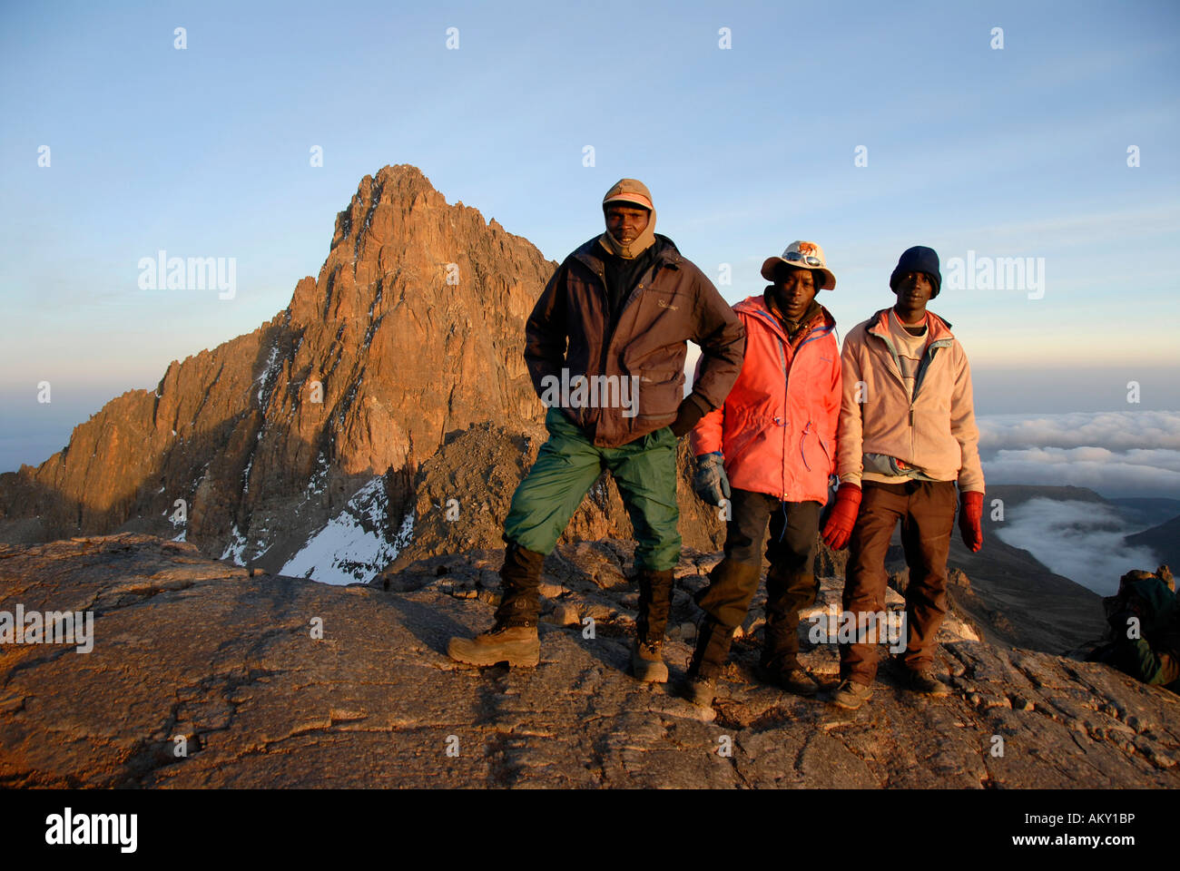 Local guides at summit Point Lenana (4985 m) with Batian (5199 m) at ...