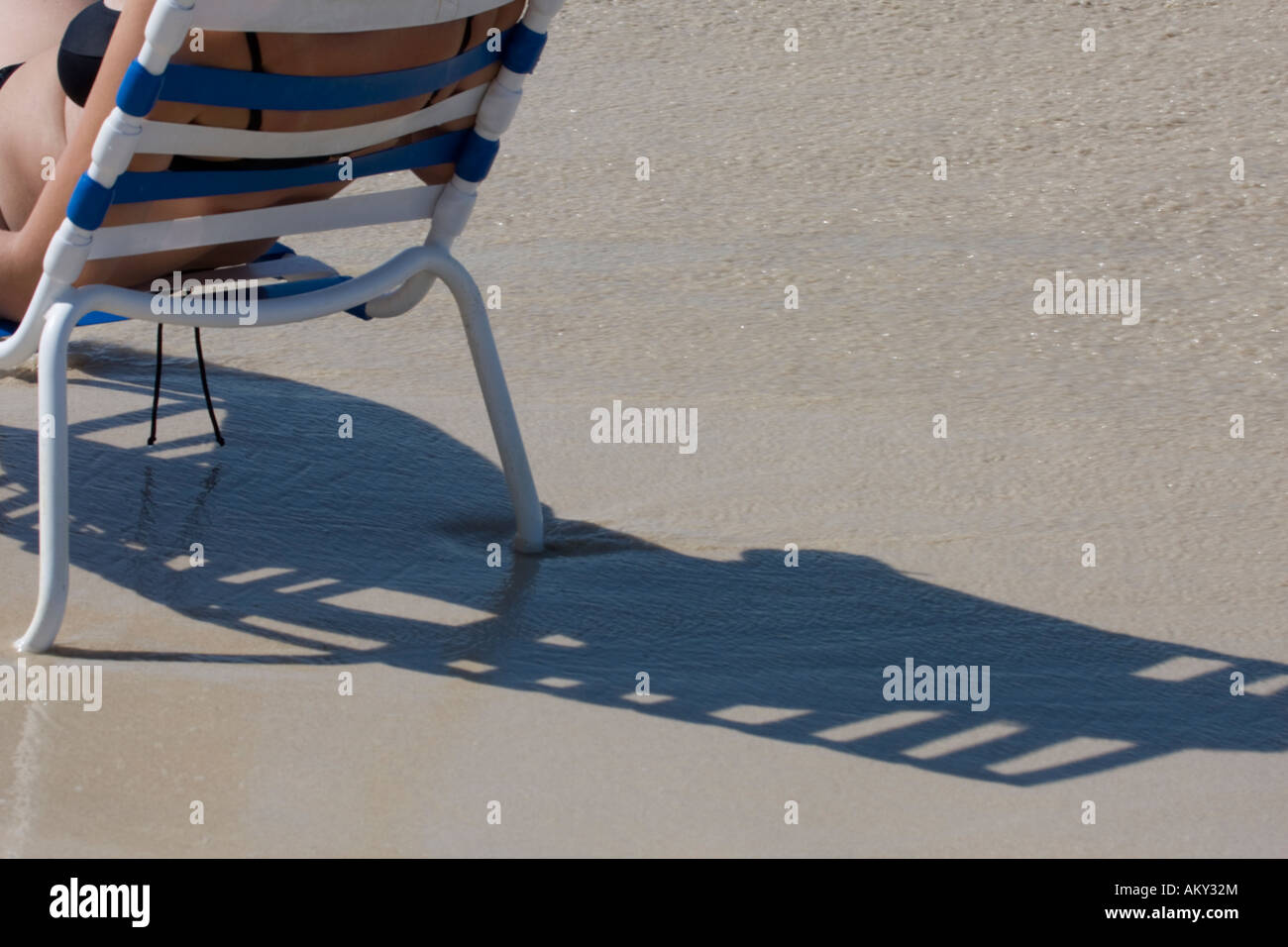 Plastic chair and shadow on beach Stock Photo - Alamy