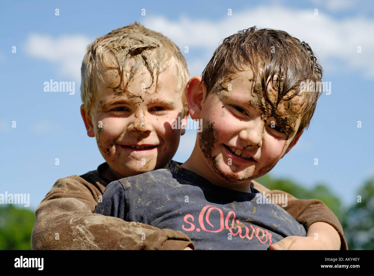 Two friends covered with mud Stock Photo - Alamy