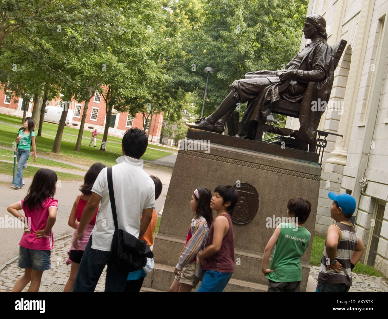 Tourists gather around the statue of John Harvard, at Harvard ...